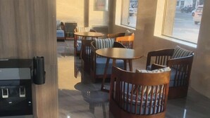 Um interior moderno com móveis de madeira, piso de mármore e grandes janelas com vista para a rua.