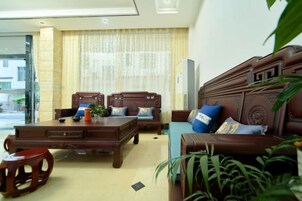 Sala de estar com sofá, mesa de centro e uma pequena mesa com uma planta.