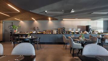 Um restaurante moderno com um balcão central, diversas áreas de estar e um design contemporâneo.