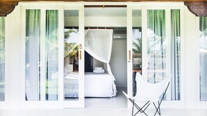 Quarto com uma cama, uma cadeira e o número 5 na porta.