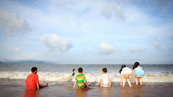 Um grupo de pessoas sentadas na praia, olhando para o oceano.