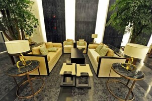 Um hall com área de estar, mesa de centro e duas luminárias.