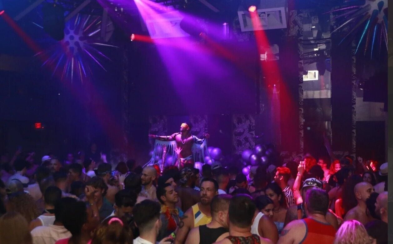 Um evento lotado em ambiente fechado, com palco e plateia.