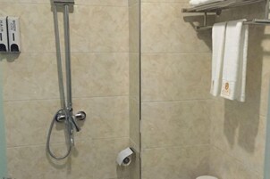 Chuveiro com chuveiro manual e torneira fixa na parede.