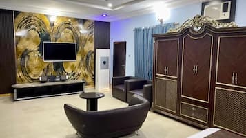 Uma sala de estar moderna com televisão de tela plana, um sofá, um armário e uma parede decorativa.