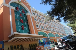 Um hotel com entrada destacada, grandes janelas e uma placa com caracteres chineses.