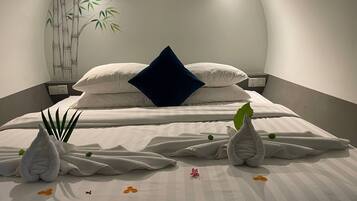 Quarto de hotel com cama, almofadas e um mural na parede.