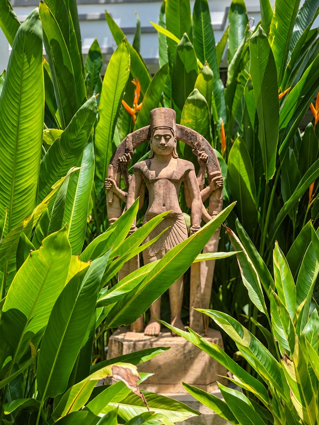 Uma estátua de pedra em meio a vegetação exuberante.