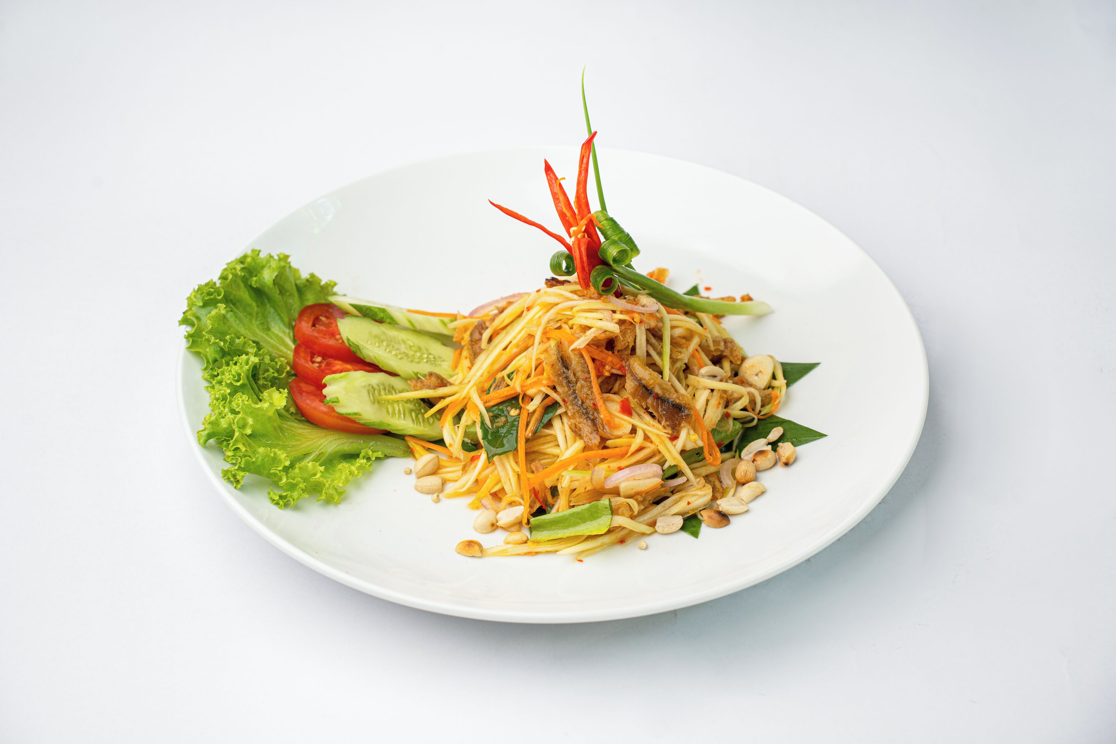 Prato de comida com diversos vegetais e amendoins.