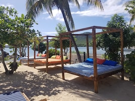 Estrutura de cama de madeira com vista para um lago e montanhas.