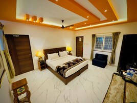 Quarto moderno com uma cama grande, um ventilador de teto e uma janela com cortinas.