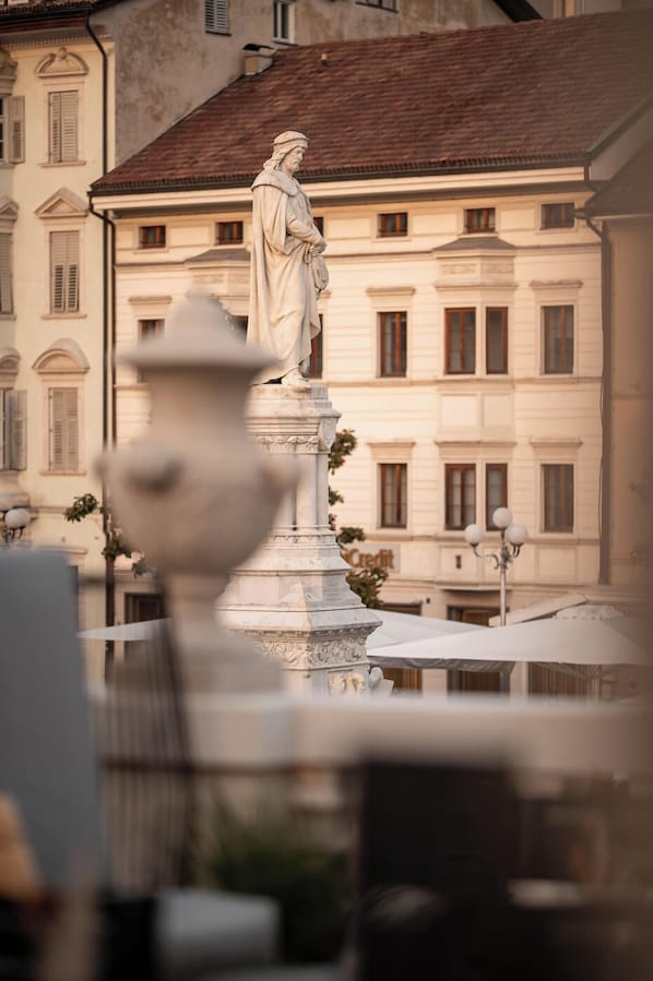 Uma estátua em um pedestal em frente a um edifício com várias janelas e uma placa com a palavra 'Credit'.