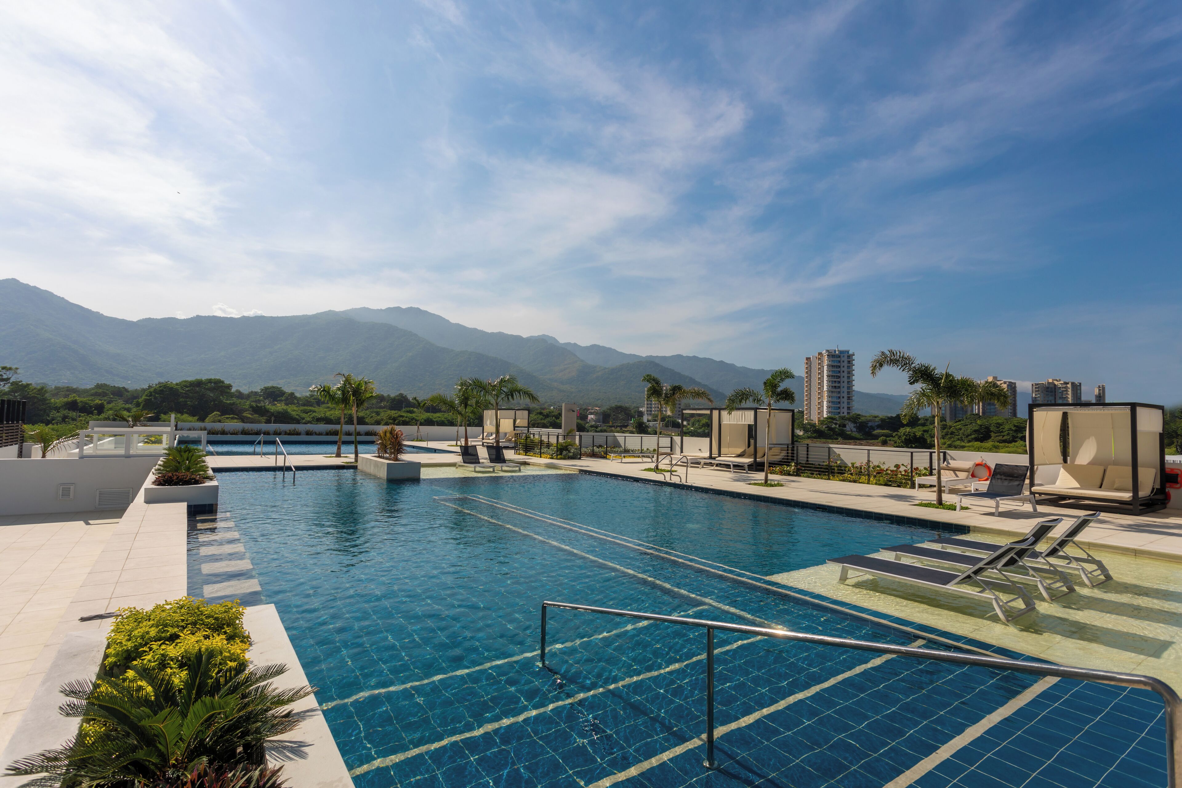 Piscina com vista para montanhas, espreguiçadeiras e um salva-vidas.