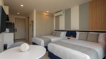 Quarto de hotel com duas camas, uma mesinha, micro-ondas e televisão.