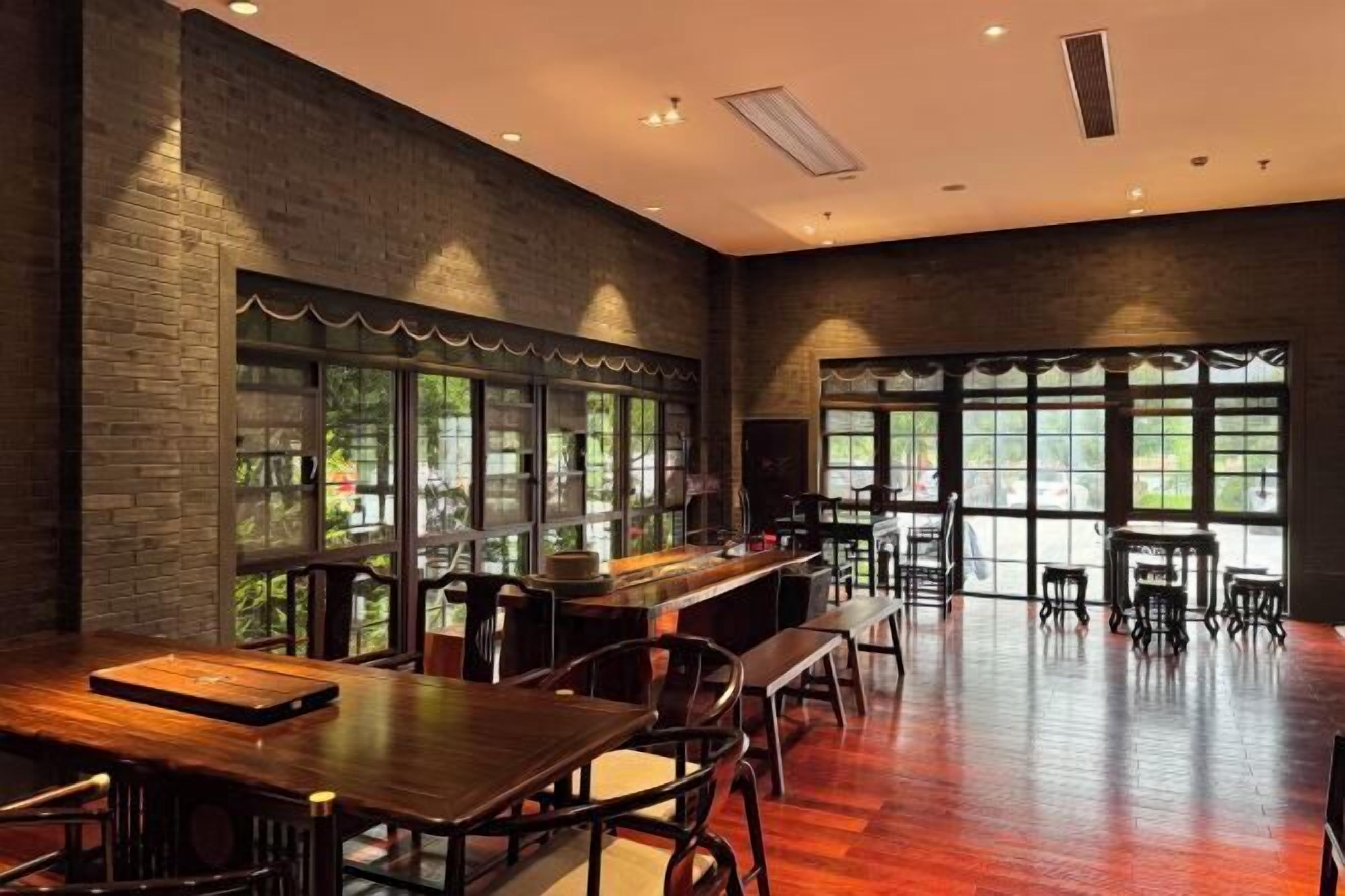 Uma sala de jantar ampla com uma longa mesa de madeira, várias cadeiras e um balcão.