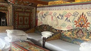 Quarto tradicional com uma cama, um sofá e um baú decorativo.