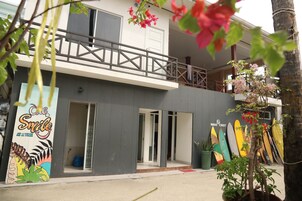 Um edifício com varanda, porta e parede com um logotipo.