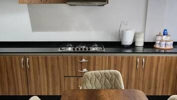 Uma cozinha moderna com armários de madeira, fogão a gás e uma mesa de jantar com cadeiras.