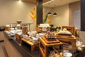 Buffet com diversos alimentos e potes de cereais.
