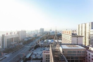 Paisagem urbana com edifícios altos, céu claro e rua movimentada.