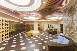 Um saguão de hotel com balcão de check-in, área de estar e uma fileira de armários.