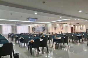 Uma ampla área de refeições com várias mesas e cadeiras, um bar e um design de teto moderno.
