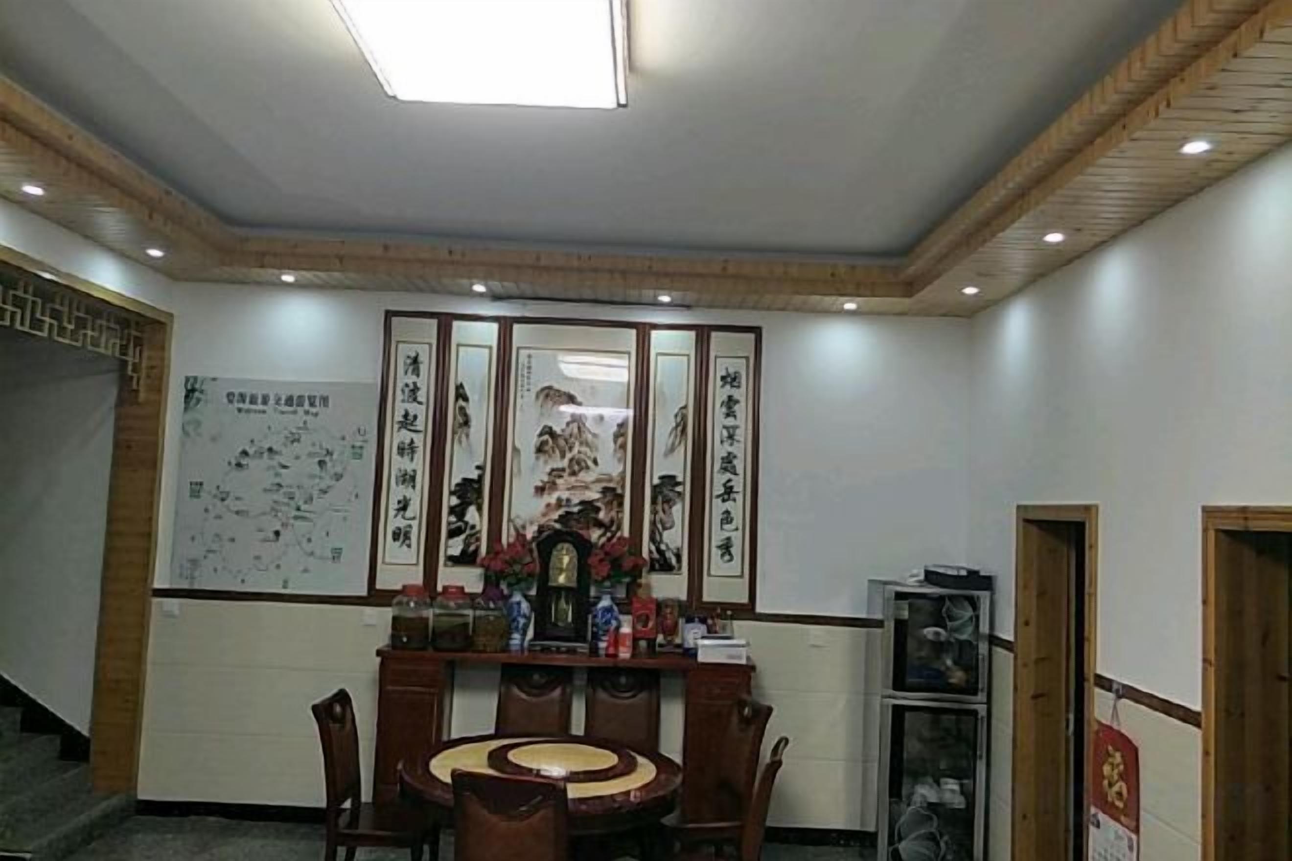 Uma sala de conferências com uma mesa redonda, cadeiras, um armário com objetos e uma parede com cartazes.