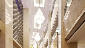 Um interior moderno com teto alto, luminárias geométricas e parede estampada.