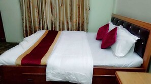 Uma cama bem arrumada com um cobertor listrado, dois travesseiros e uma cabeceira de madeira.