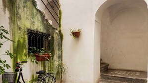 Piso xadrez, uma bicicleta, um vaso de planta e uma escada.