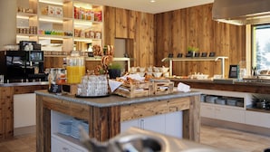Uma cozinha moderna com detalhes em madeira, um espaço para café e diversos alimentos à mostra.