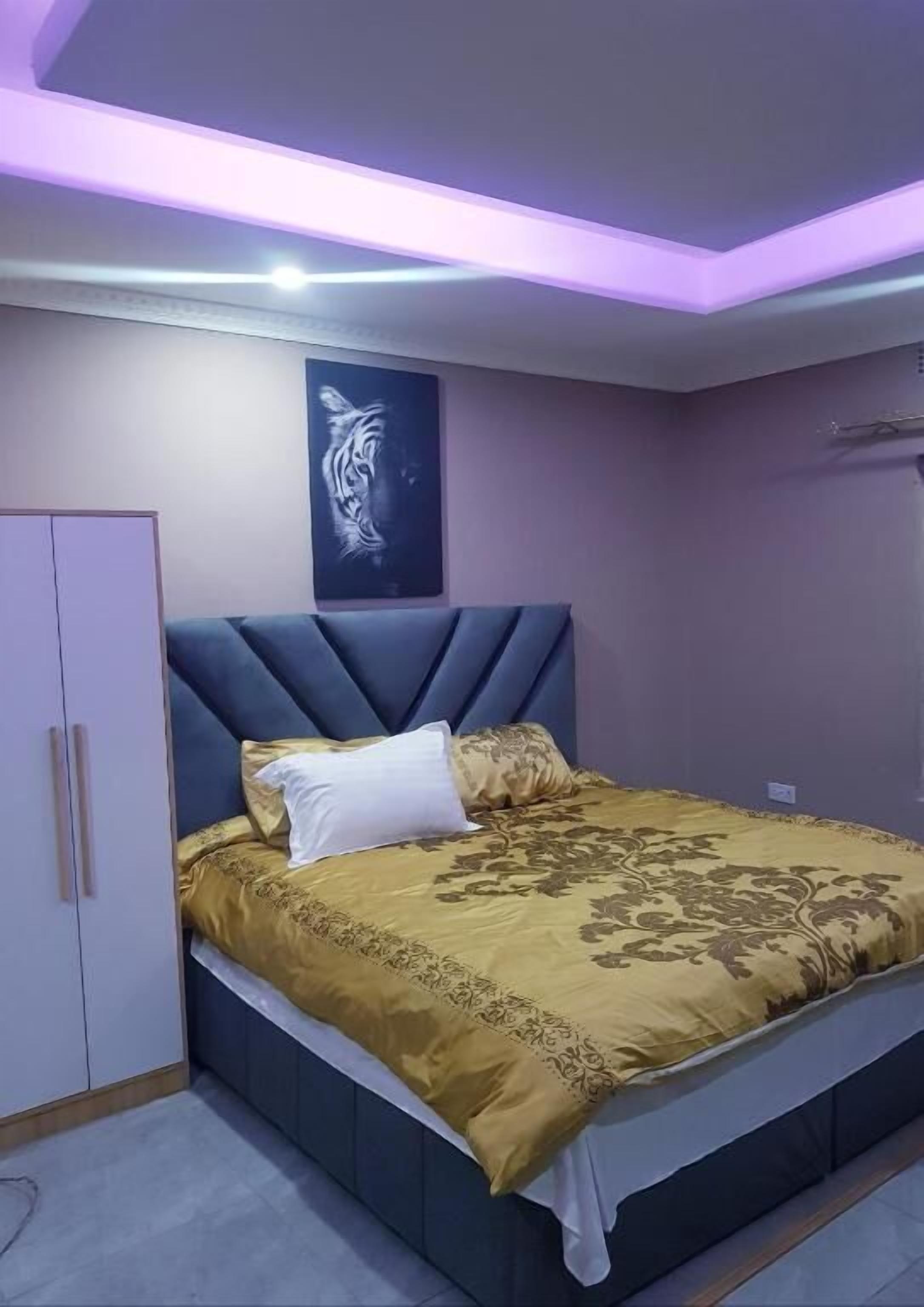 Quarto com cama, guarda-roupa e uma obra de arte pendurada na parede.