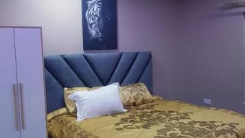Quarto com cama, guarda-roupa e uma obra de arte pendurada na parede.