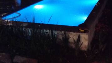 Uma piscina à noite iluminada por uma luz azul.