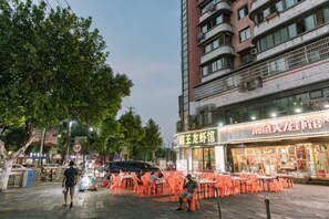 Um edifício com área externa para sentar e uma placa em idioma estrangeiro.