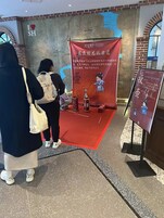 Evento com tapete vermelho, um banner e um mapa ao fundo.