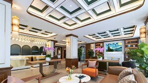 Um hall amplo com balcão de recepção, área de estar e um quadro na parede.
