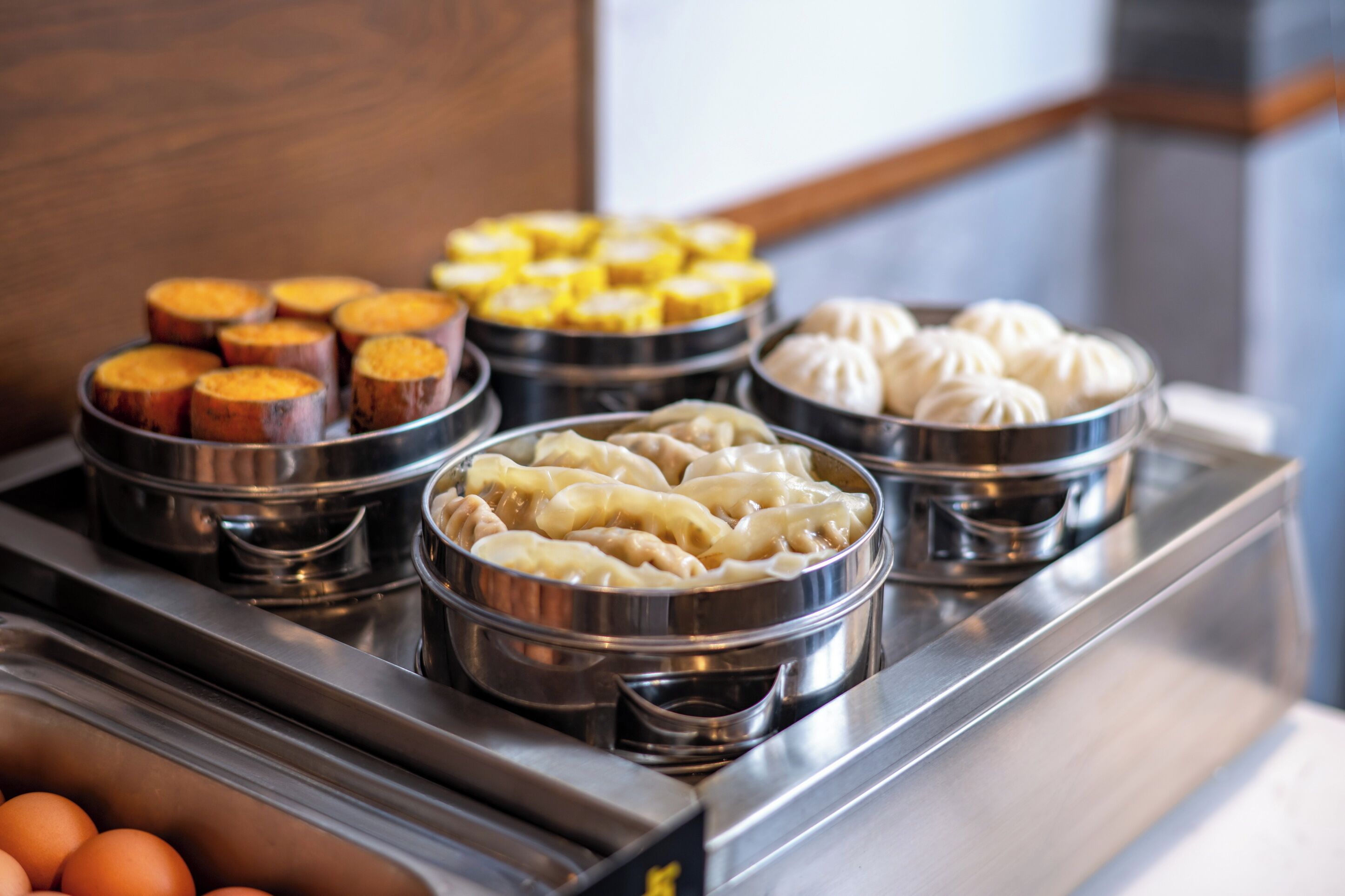 Buffet com diversos alimentos em recipientes de metal.