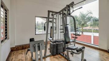 Uma academia com suporte para agachamento, supino e pilhas de peso.