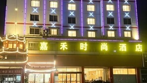 Um hotel com janelas iluminadas e uma placa de neon.