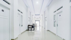 Um corredor comprido e estreito com portas brancas numeradas 109 e 104.