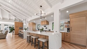 Uma cozinha moderna com ilha central, armários de madeira e uma janela ampla.