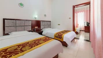 Quarto de hotel com duas camas, uma mesa de cabeceira, uma luminária e uma televisão.