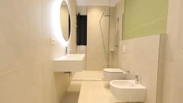 Casa de banho moderna com lavatório, bidé e chuveiro.