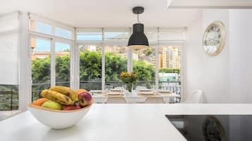 Apartamento família, vista para a cidade | Área de estar | TV de tela plana 50 polegadas com canais a cabo