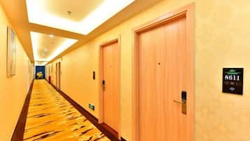 Corredor de hotel com portas de madeira, piso coberto por carpete e uma placa indicando a sala número 8611.