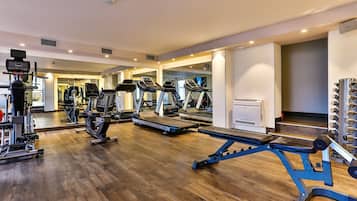 Uma academia com esteiras, elípticos e equipamentos de musculação.