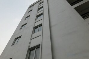 Um edifício alto com várias janelas e fachada plana.