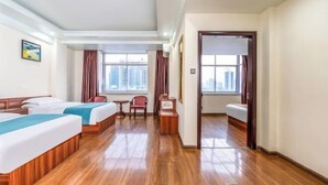 Quarto de hotel com duas camas, uma mesa pequena, uma cadeira e vista para a cidade.
