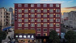 Um hotel de vários andares com fachada vermelha e várias janelas.